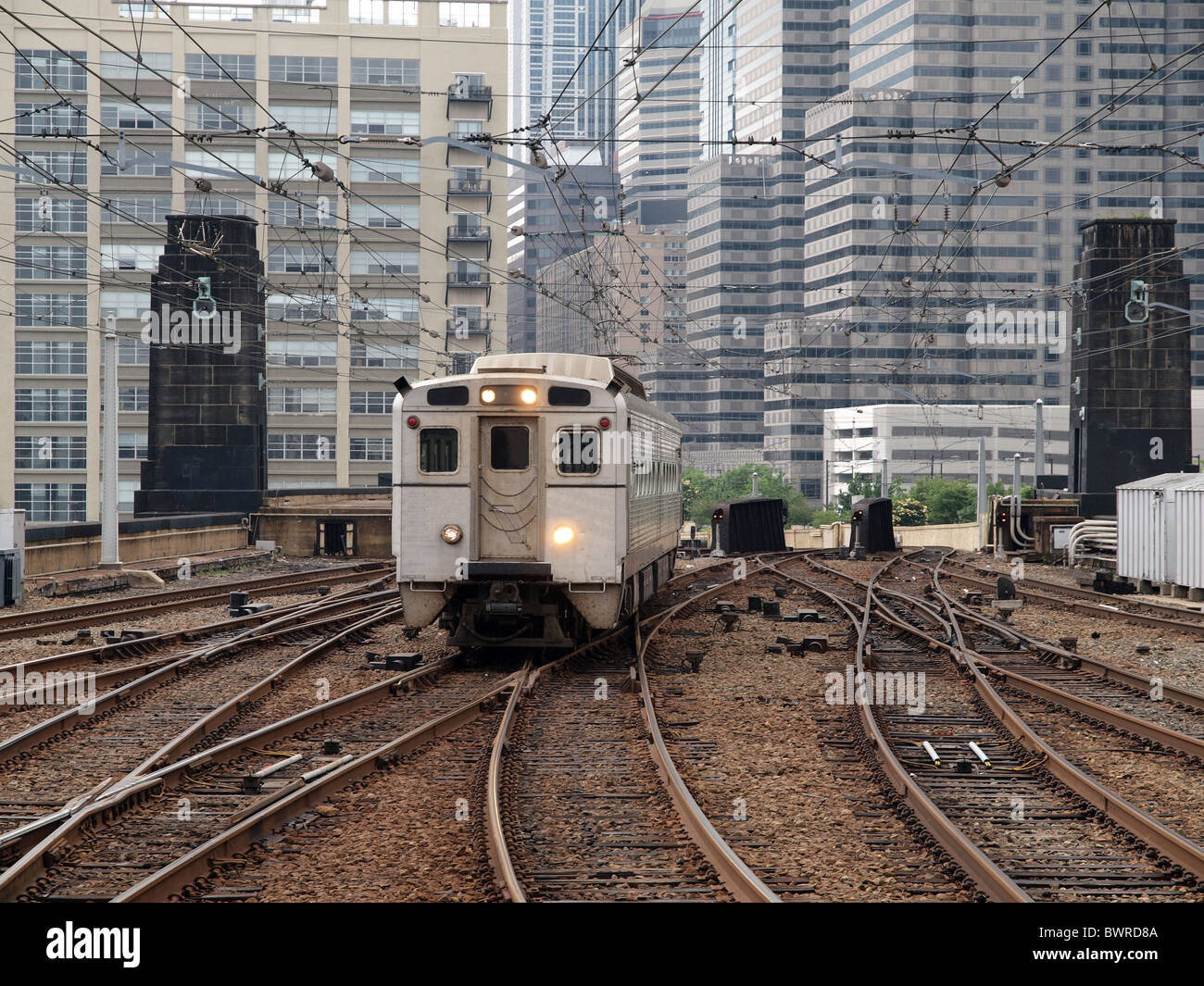 Urban passenger train with dense cityscape background Stock Photo - Alamy