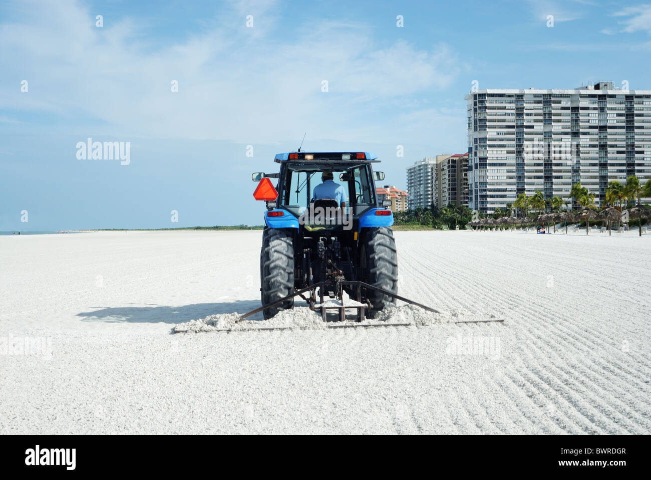 Tractor raking sand on beach in South Florida. Beach maintenance Stock ...