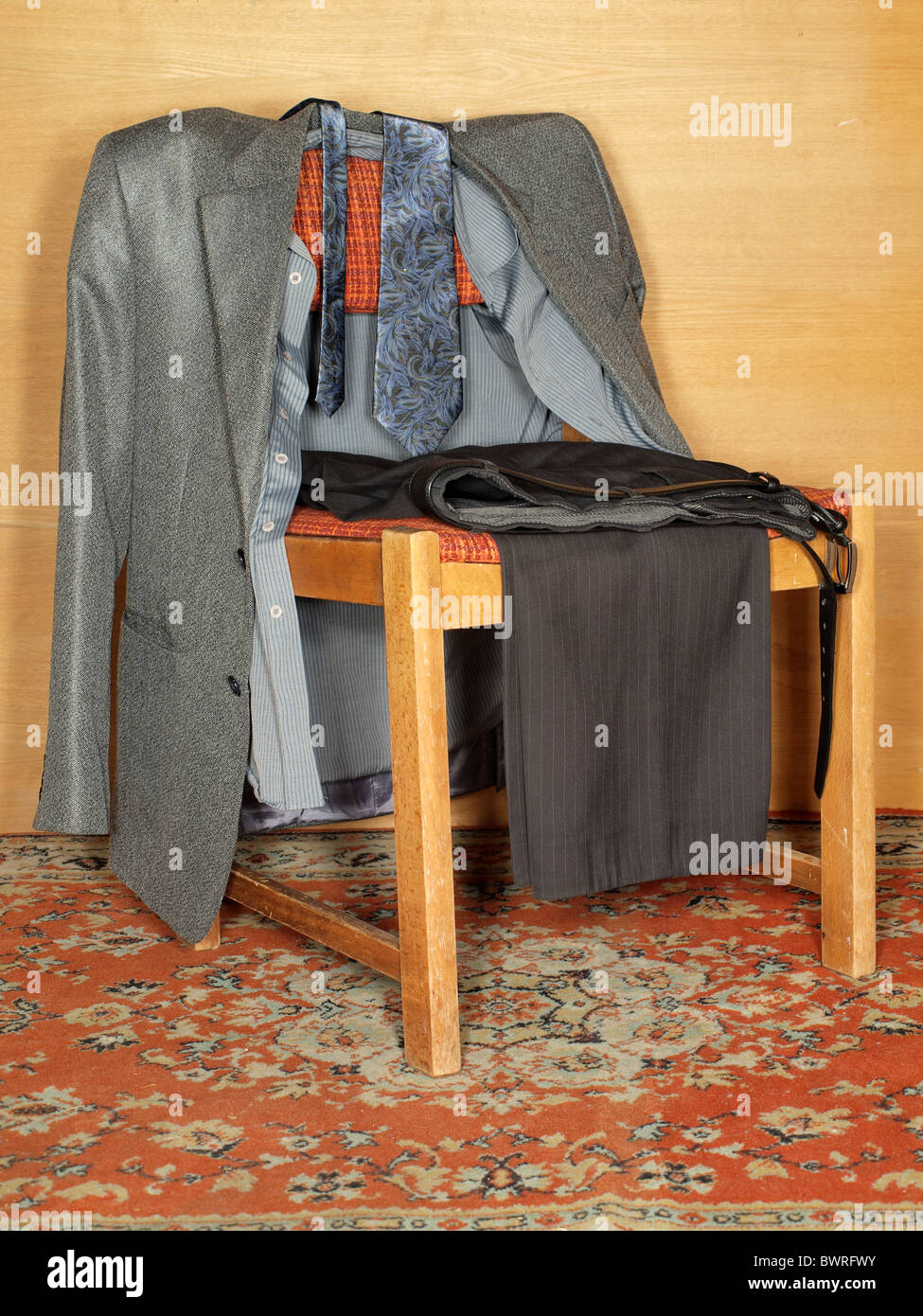Clothes hanging on an old chair Stock Photo - Alamy