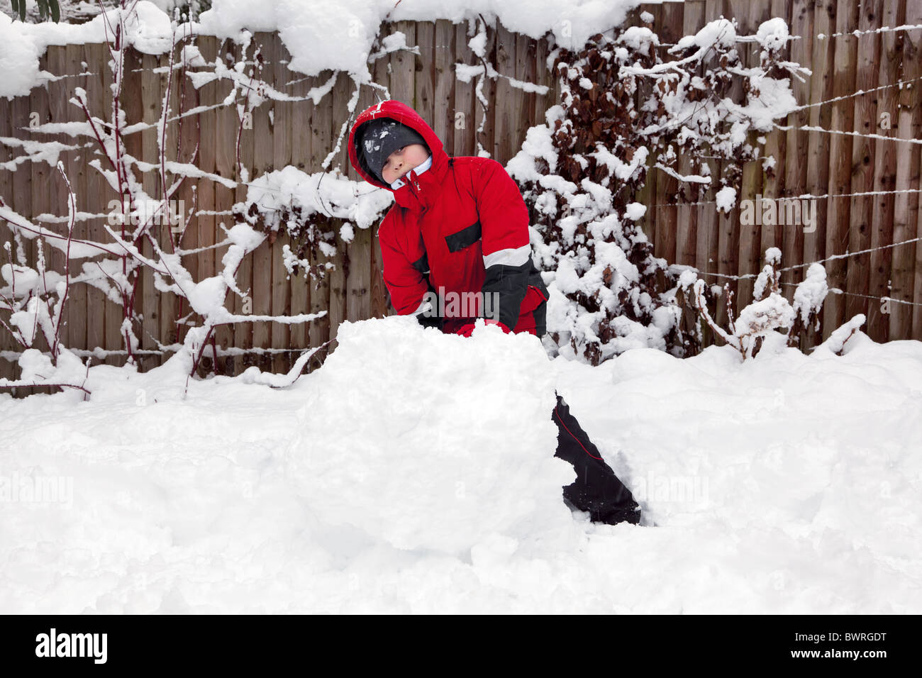 Children rolling snowball snowman hi-res stock photography and images ...