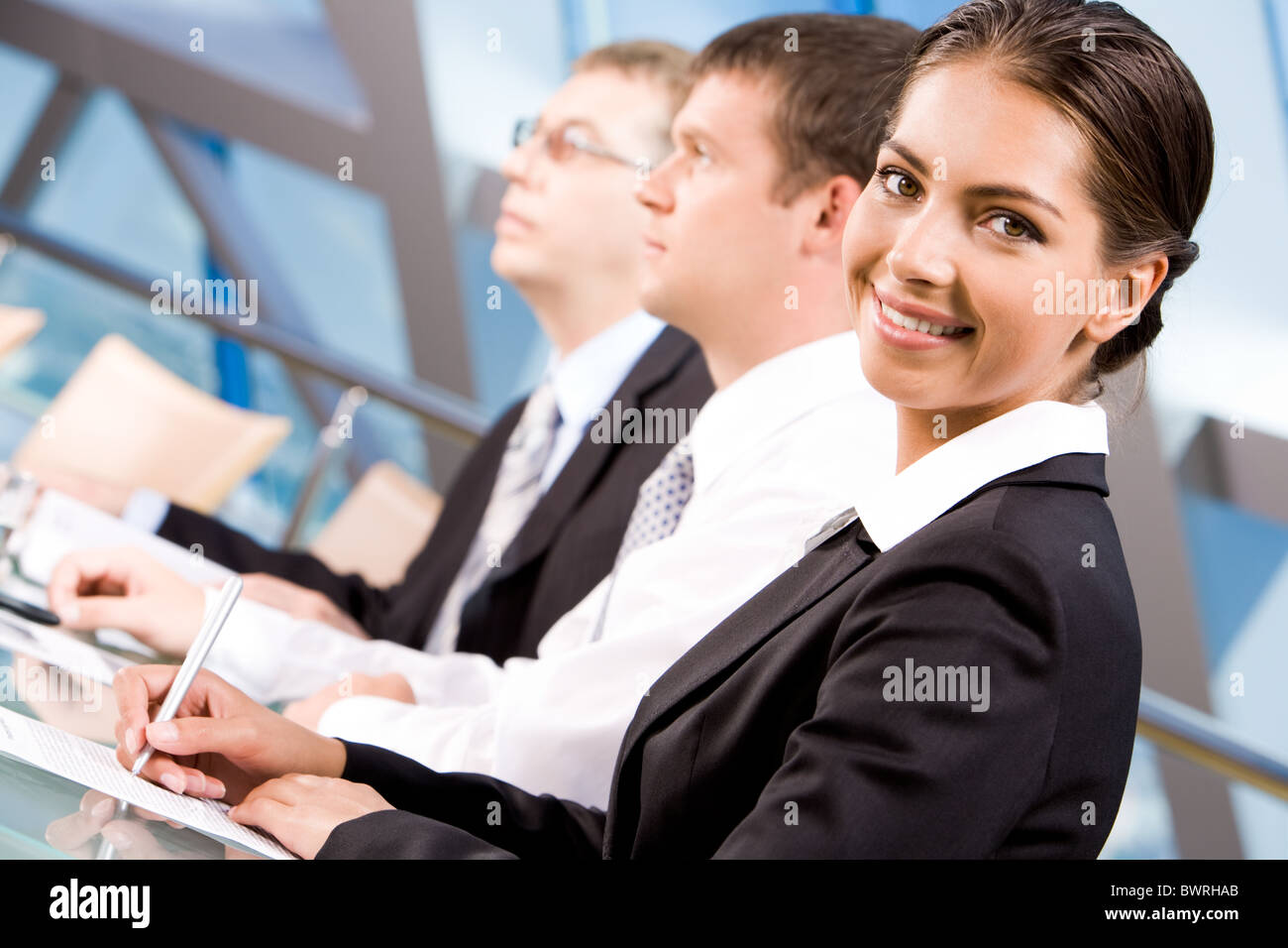 Pretty white collar worker is writing a text during business conference ...