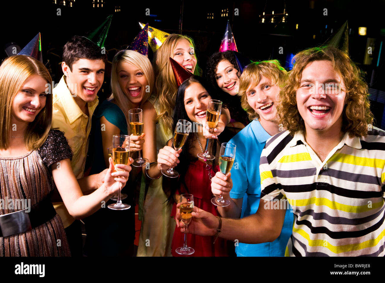 Portrait of glad people in smart clothing toasting at birthday party ...
