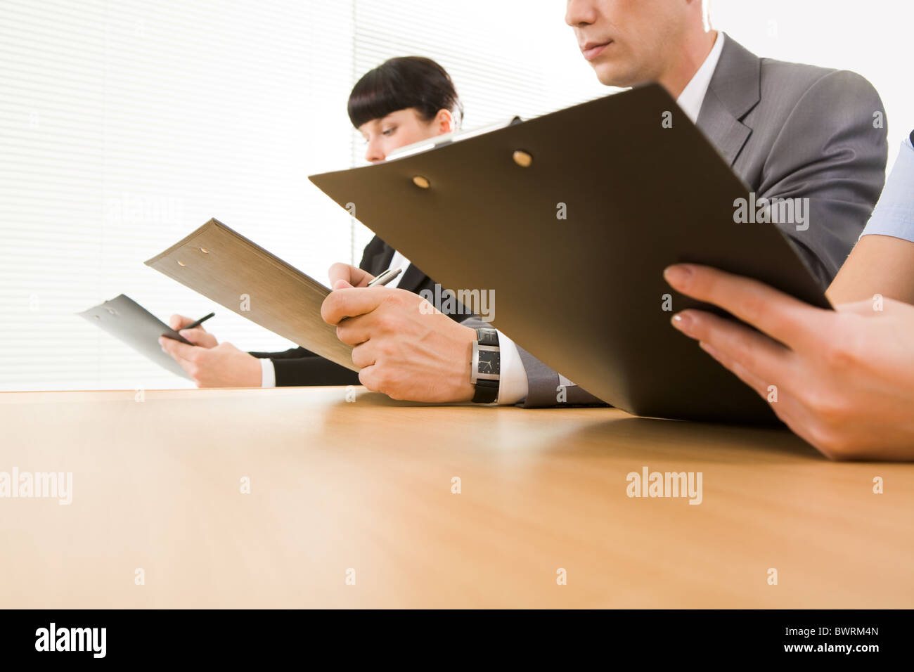 Row of human hands holding papers and reading them Stock Photo - Alamy