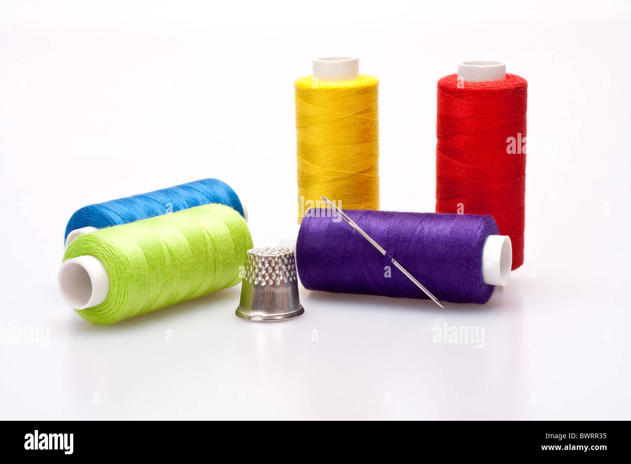 multi-colored rainbow threads for sewing with needle and thimble Stock ...