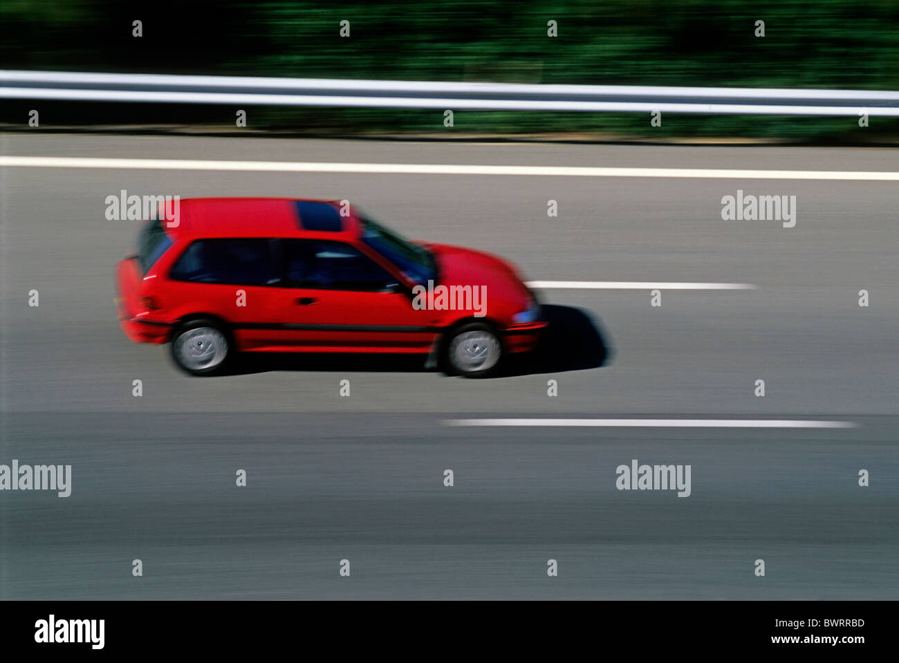 Speeding red car travelling on a highway Stock Photo - Alamy
