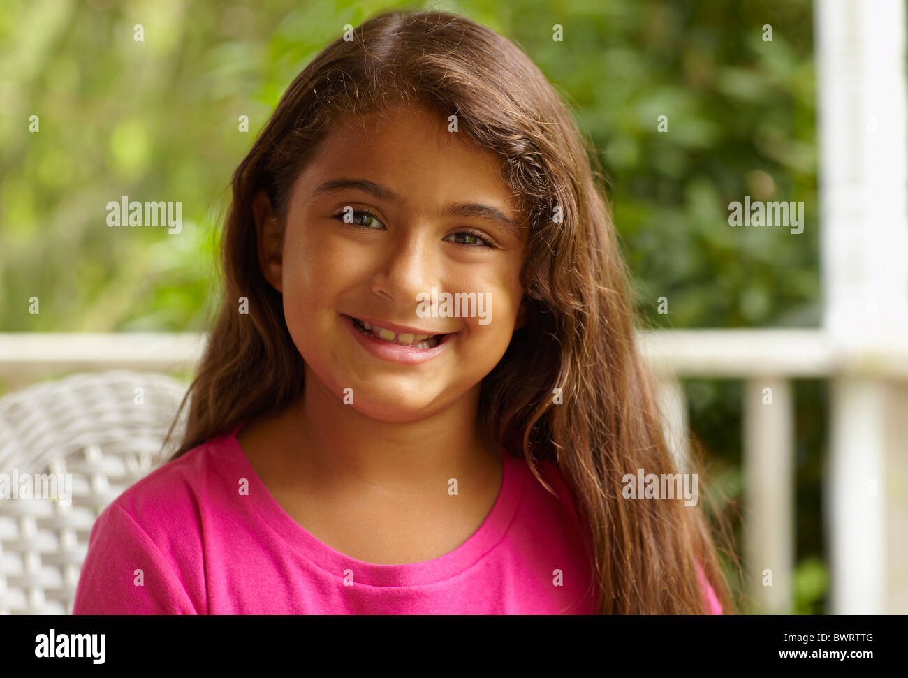 Smiling Hispanic girl sitting in porch Stock Photo - Alamy