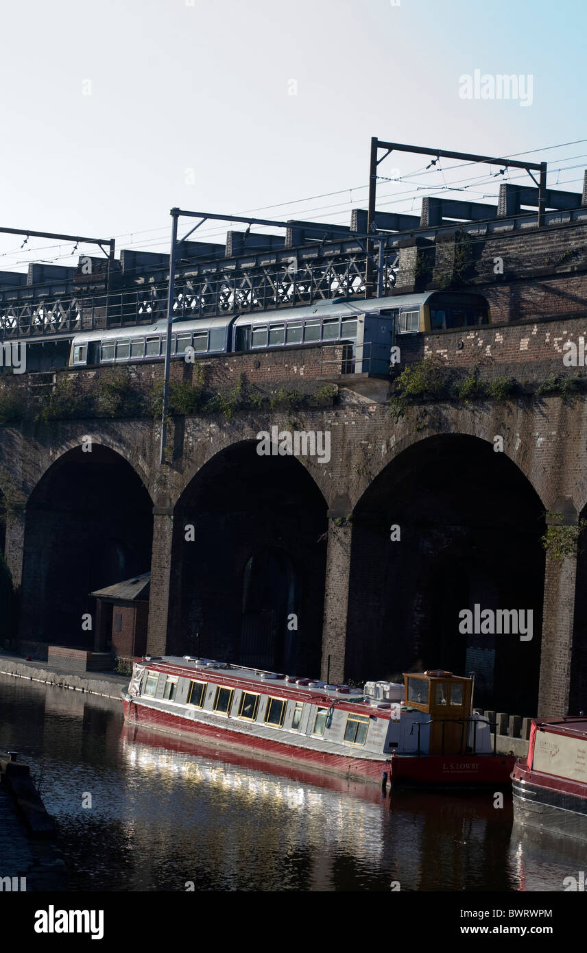 Train crossing viaduct above Castlefield Canal Basin Manchester England ...