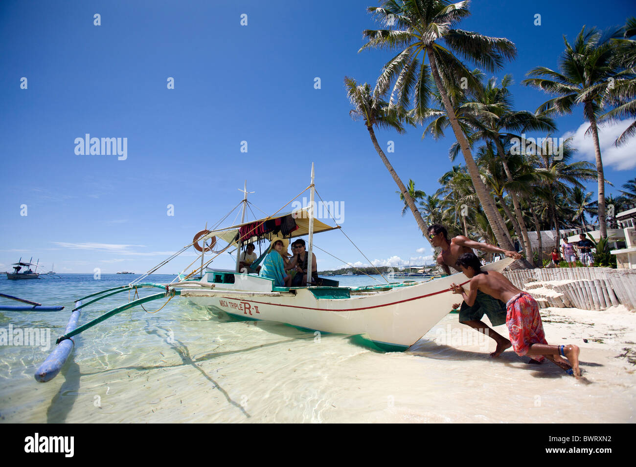 Filipinos shove a bangka boat loaded with tourists off of Bulabog Beach ...