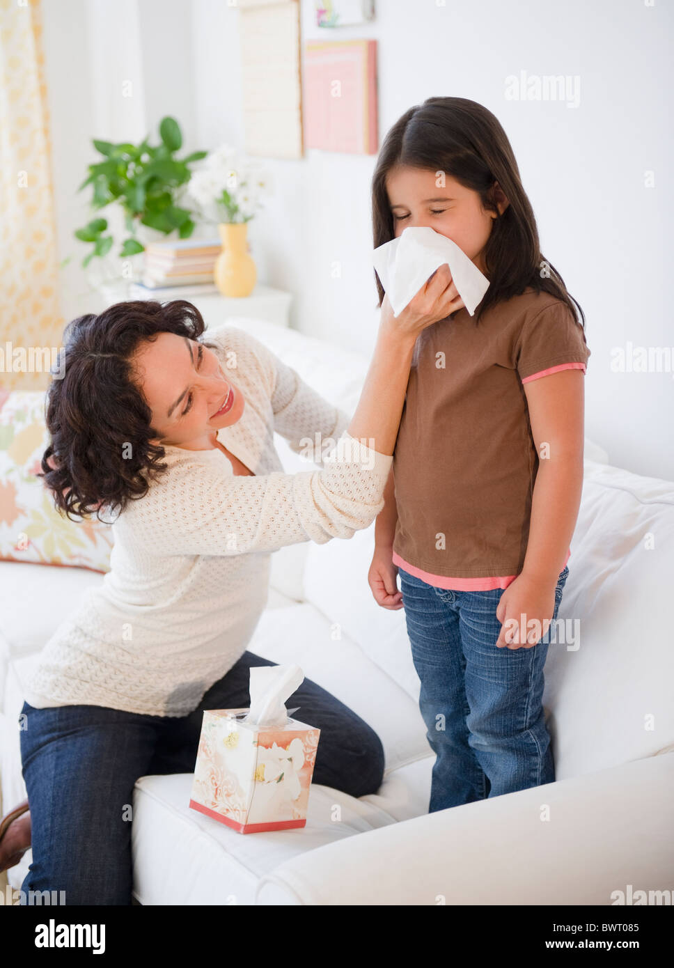 Mother wiping sick daughter's nose with tissue Stock Photo - Alamy