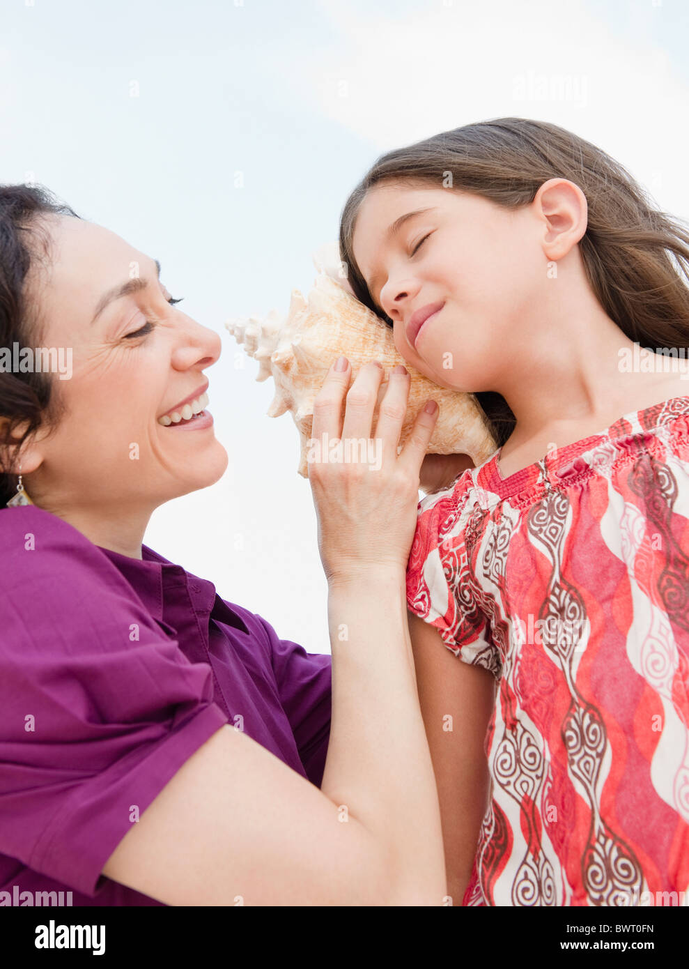 Woman holding conch shell ear hi-res stock photography and images - Alamy