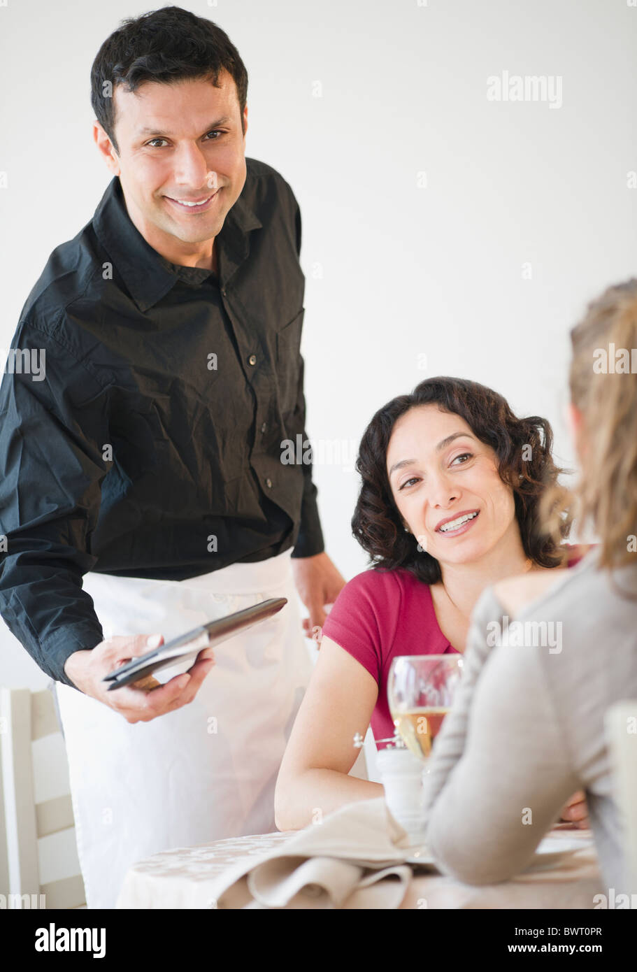 Waiter bring check to customers at table in restaurant Stock Photo - Alamy