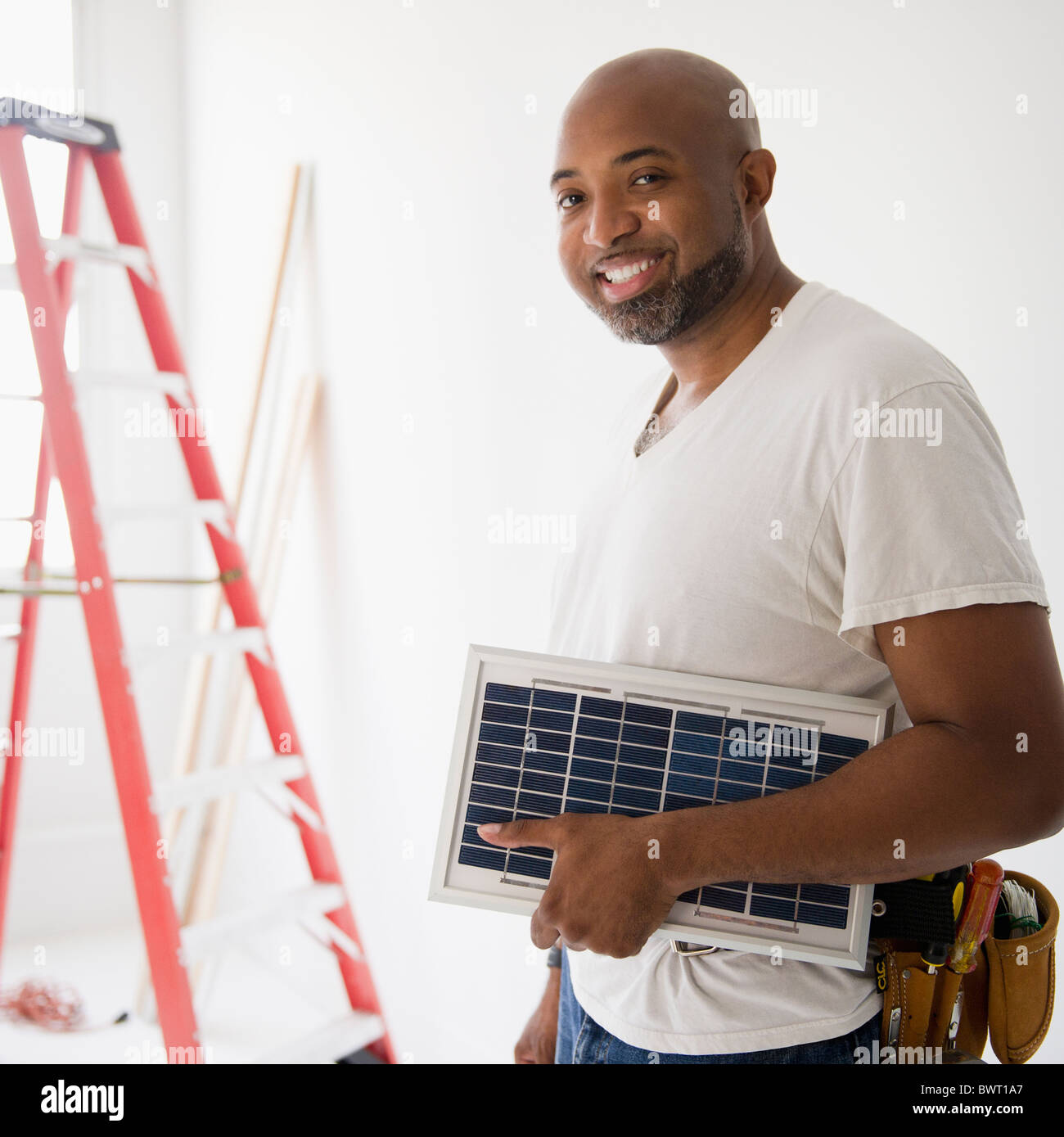 African American construction worker carrying solar panel Stock Photo ...