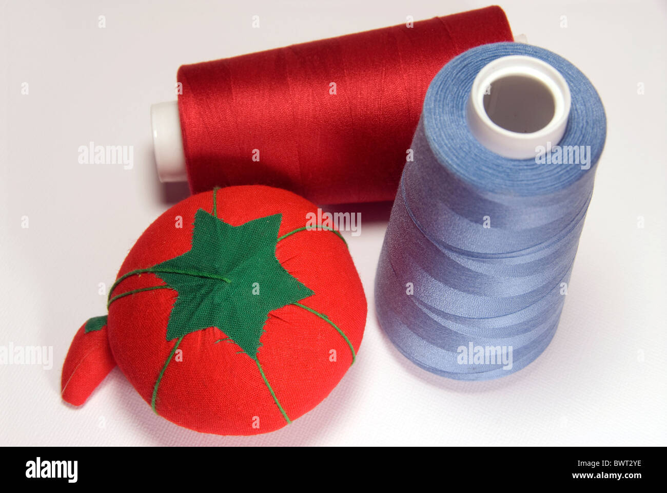 Pin cushion and thread on a white background Stock Photo - Alamy