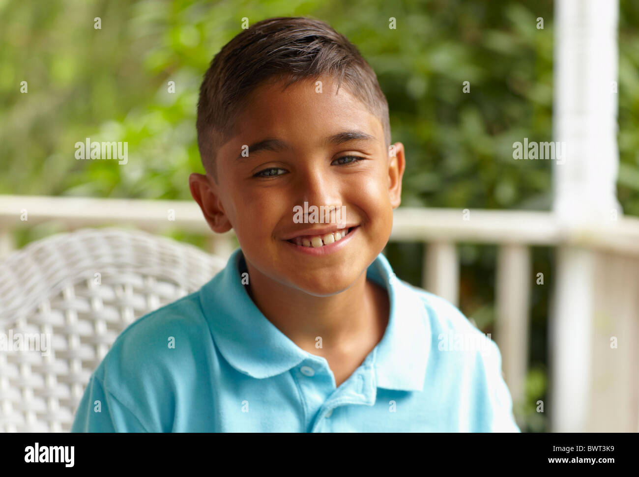 Smiling Hispanic boy sitting on porch Stock Photo - Alamy