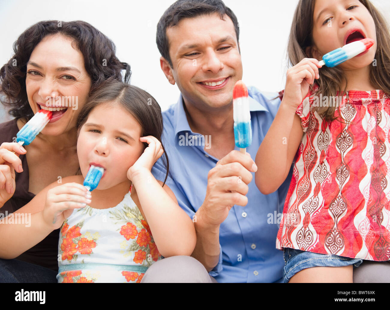 Smiling family eating popsicles together Stock Photo - Alamy