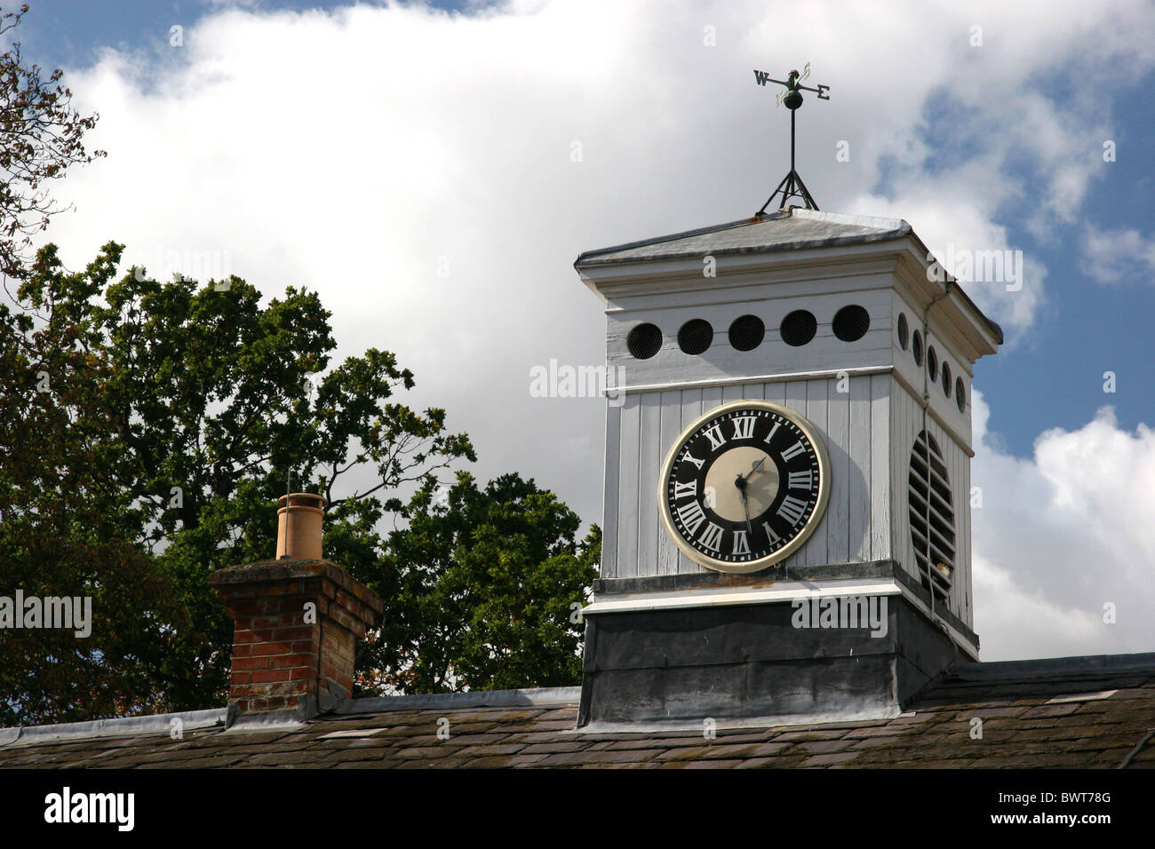 white clock tower with a clock face with roman numerals Stock Photo - Alamy