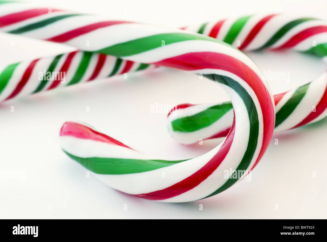 Colored candy cane as closeup on white background Stock Photo - Alamy