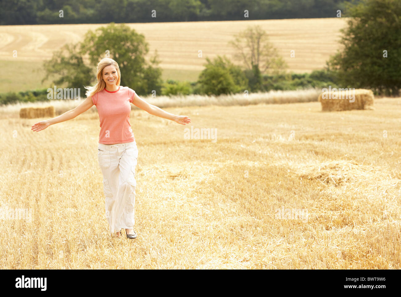 Woman Running Through Summer Harvested Field Stock Photo - Alamy