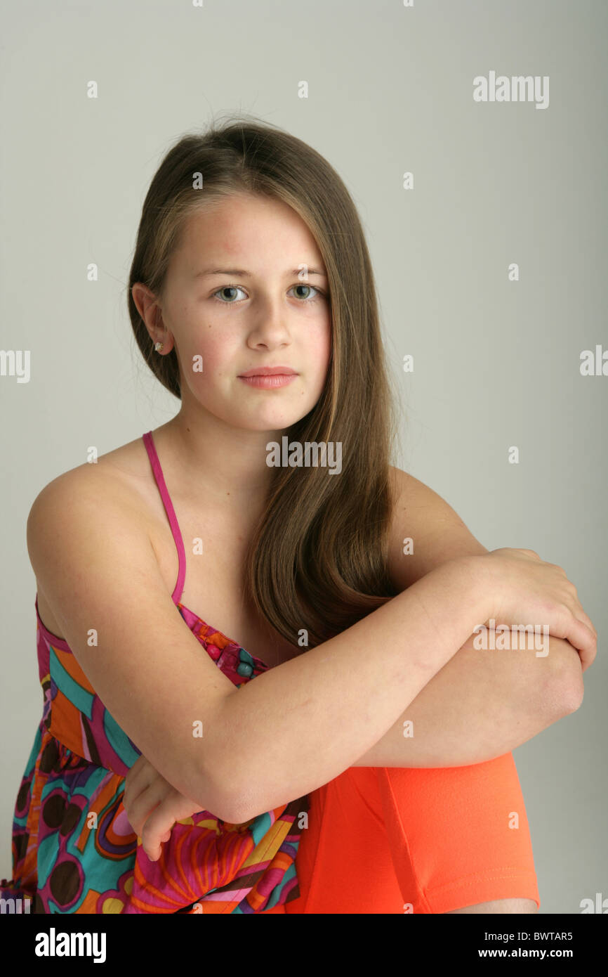 Portrait of a pretty ten year old girl sitting on the floor Stock Photo ...
