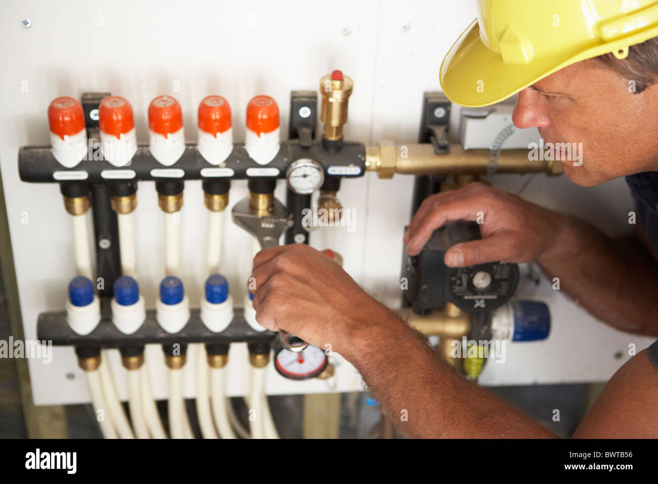 Plumber Working On Pipework In New Home Stock Photo - Alamy