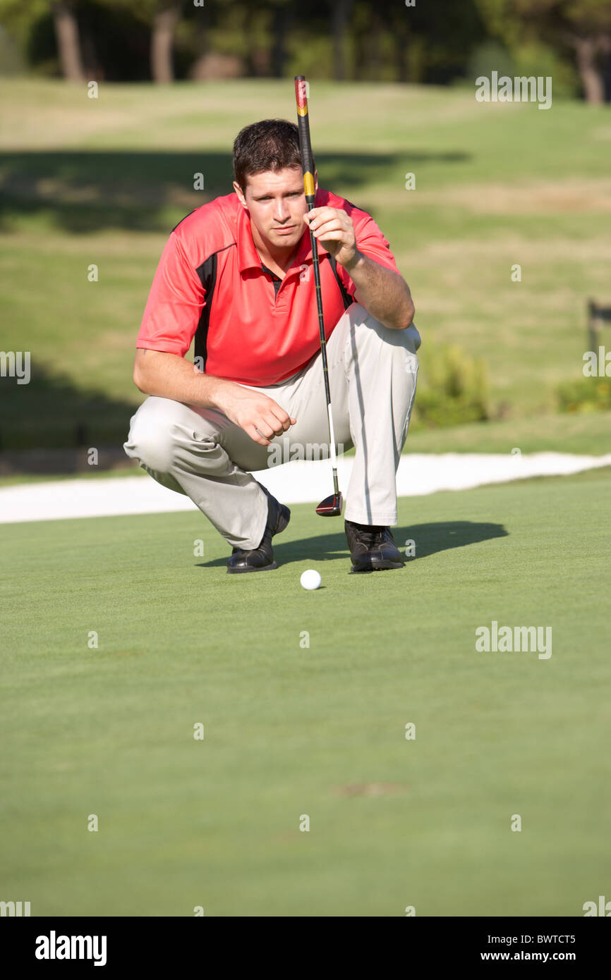 Male Golfer On Golf Course Lining Up Putt On Green Stock Photo - Alamy