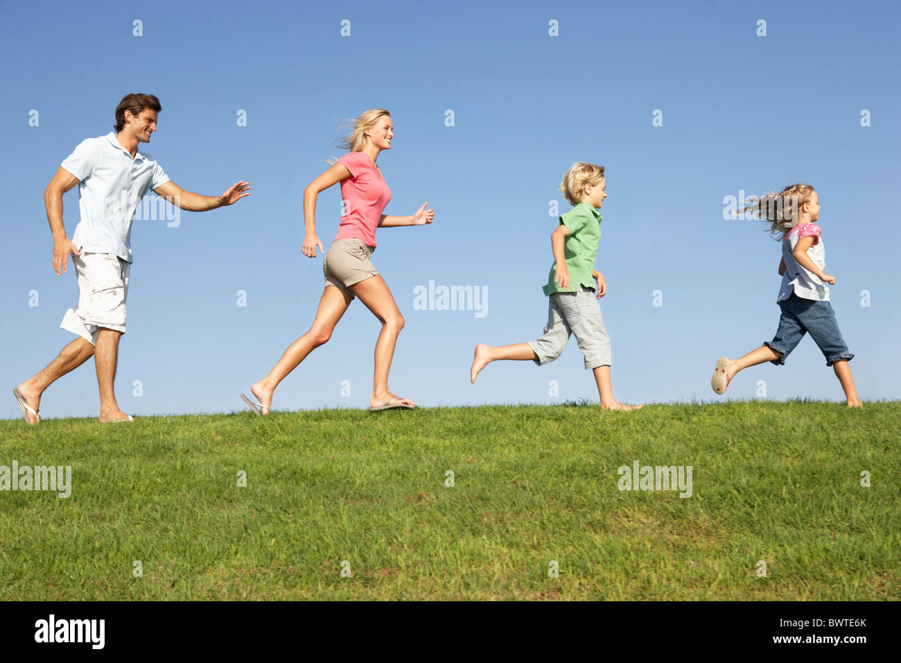 Young family, parents children running field Stock Photo - Alamy