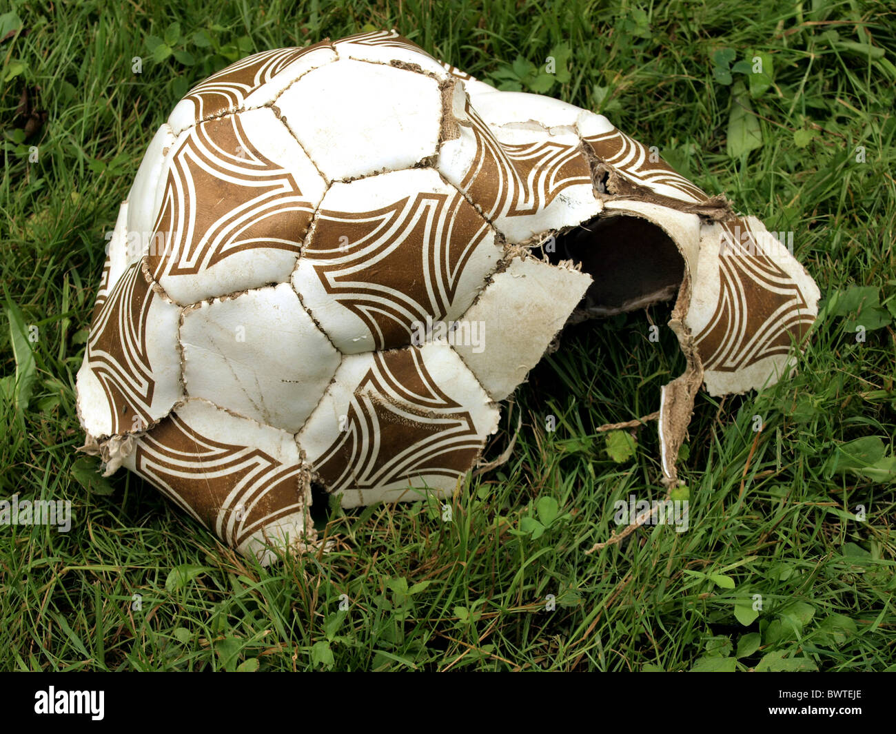 The broken off football on a green grass Stock Photo - Alamy