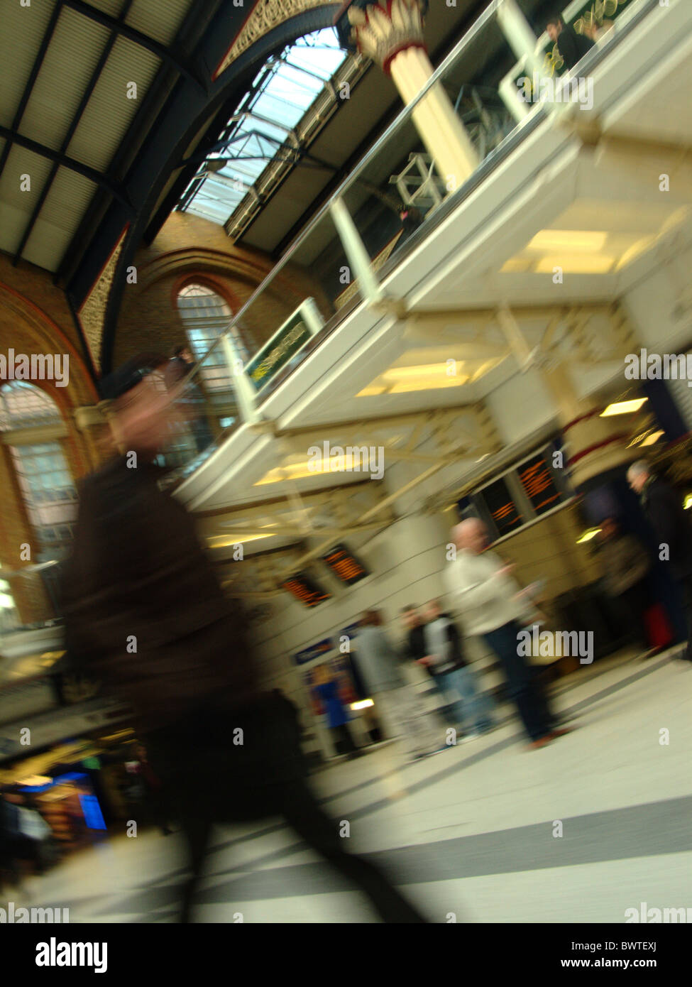 Abstract street scene - man walking purposefully across the concourse ...