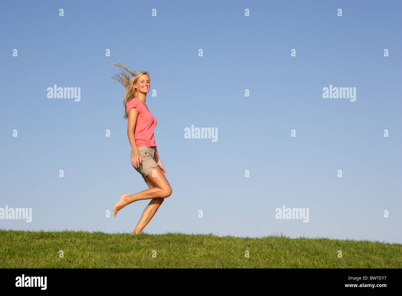 Young woman running through field Stock Photo - Alamy