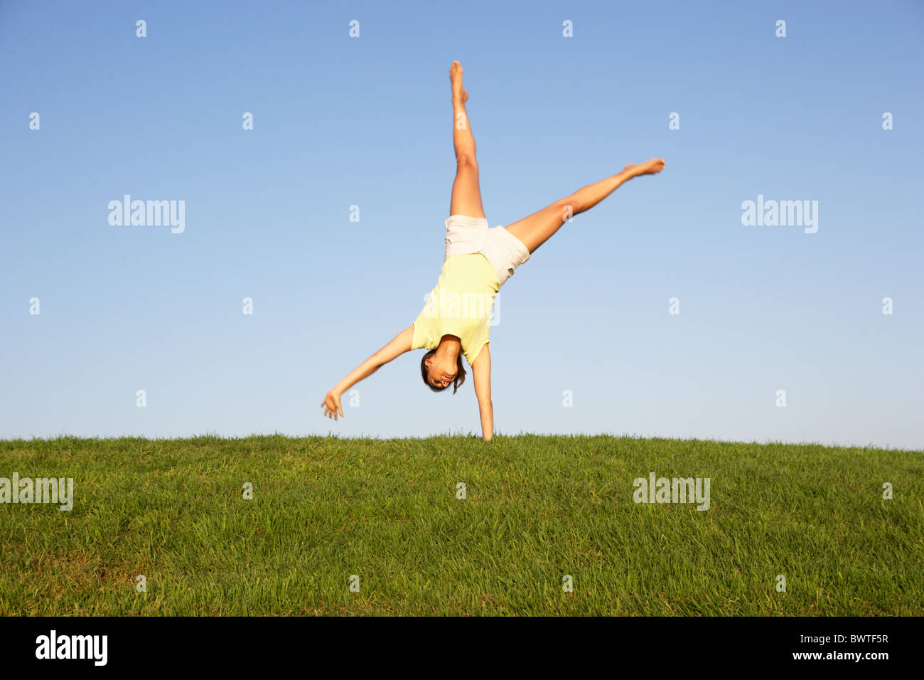 Young woman cartwheels in field Stock Photo - Alamy