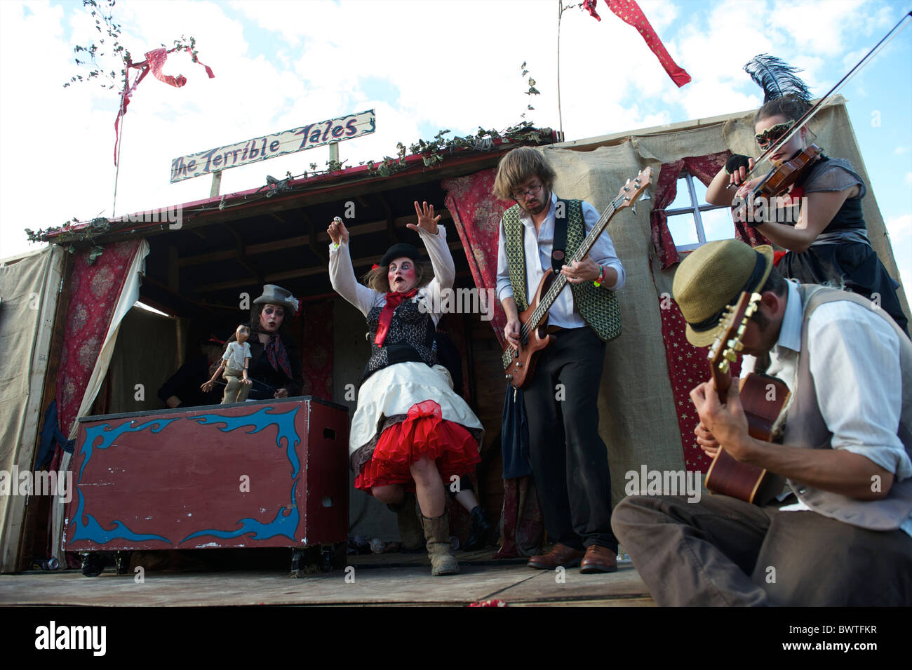 A travelling troupe of actors and musicians entertain a crowd on the ...