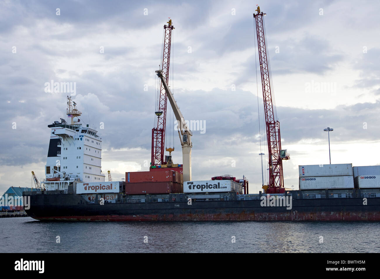Cargo ship in harbor with cranes and shipping containers Stock Photo ...