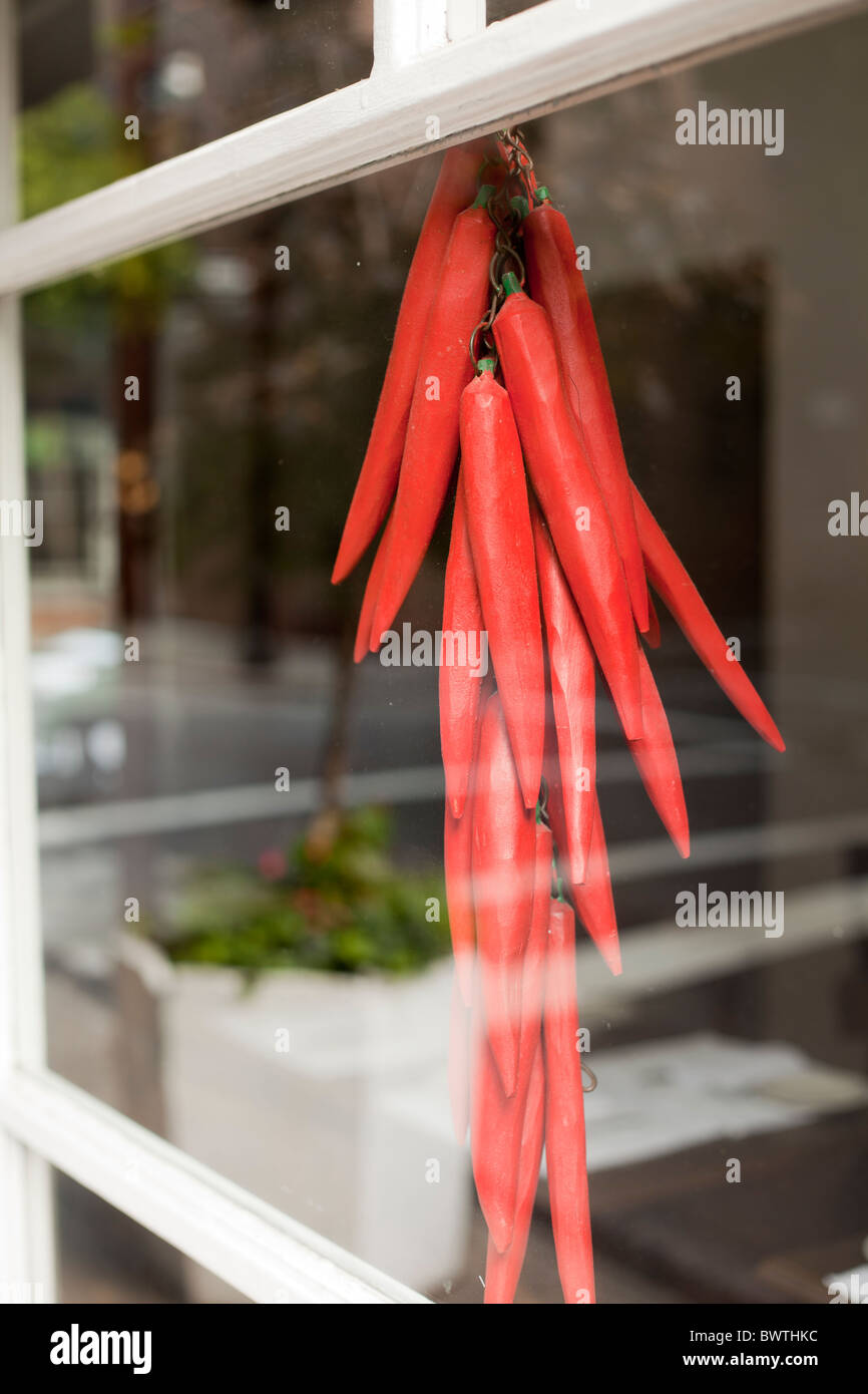 Wooden chillies hanging in a restaurant window Stock Photo - Alamy