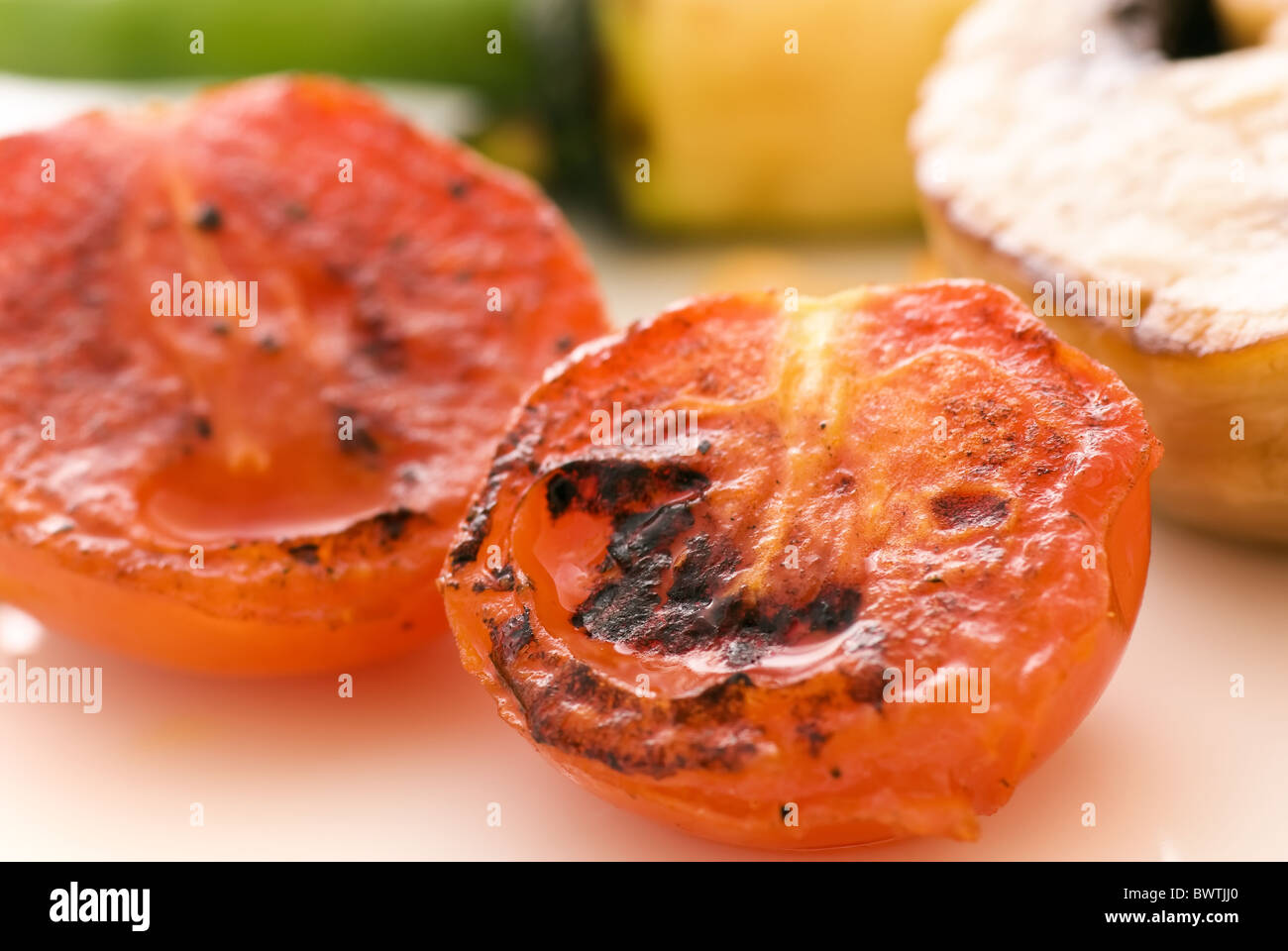 Grilled tomatoes as closeup on white background Stock Photo - Alamy