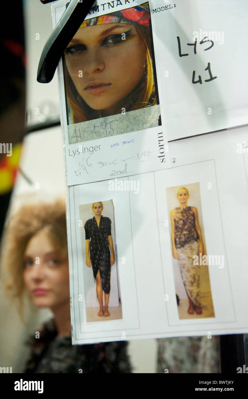Headshots of models line the clothes racks backstage before the Aminaka ...