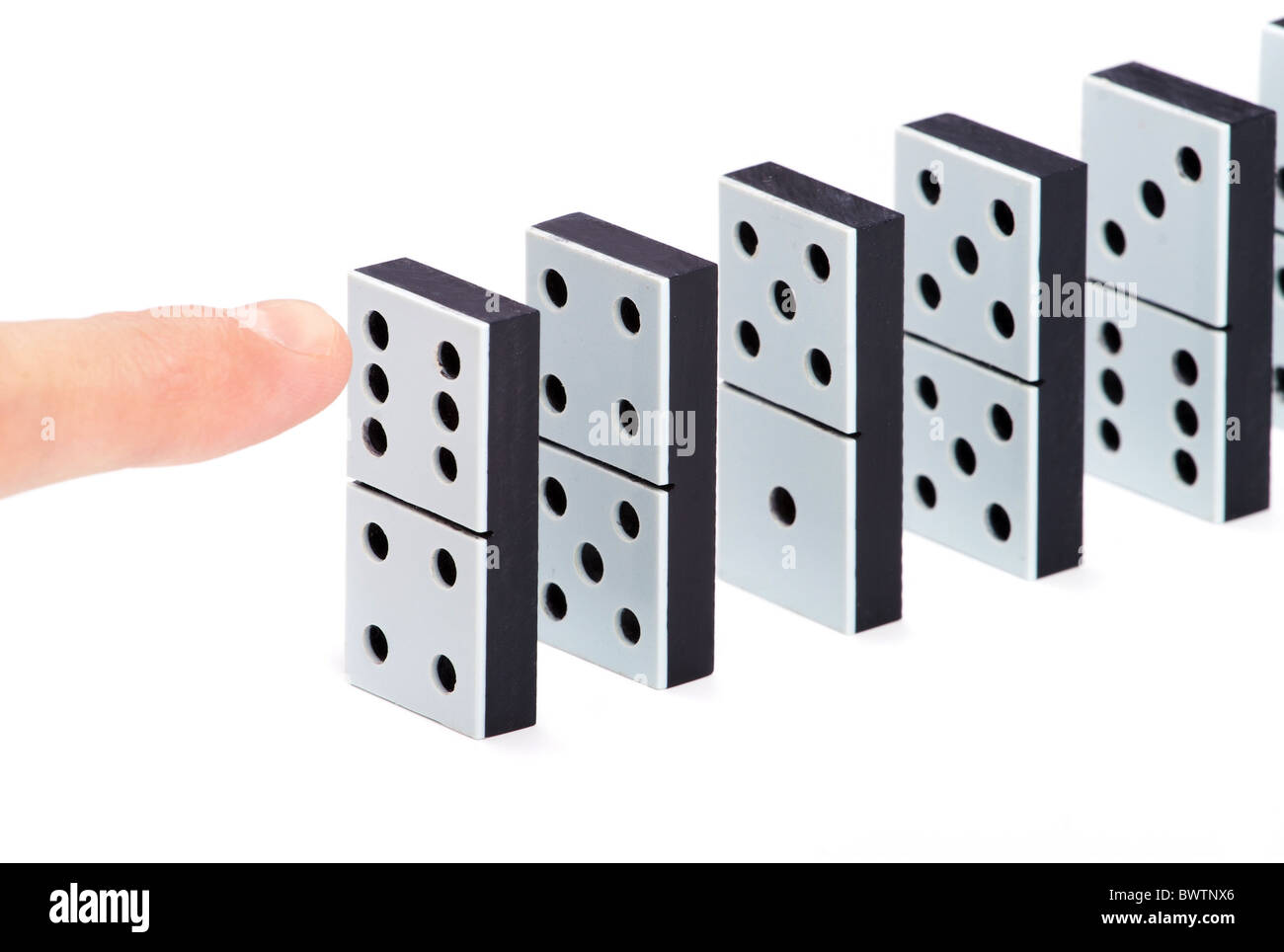 Finger ready to push domino pieces to cause chain reaction Stock Photo ...