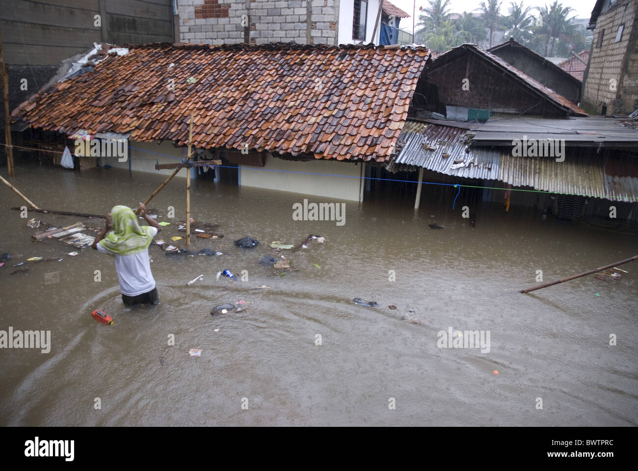 Flood victim wading through flooded street Stock Photo - Alamy