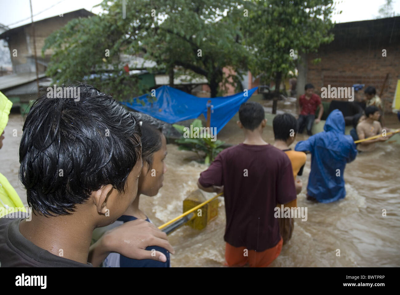 Flood victims queuing walk through fast-moving Stock Photo - Alamy