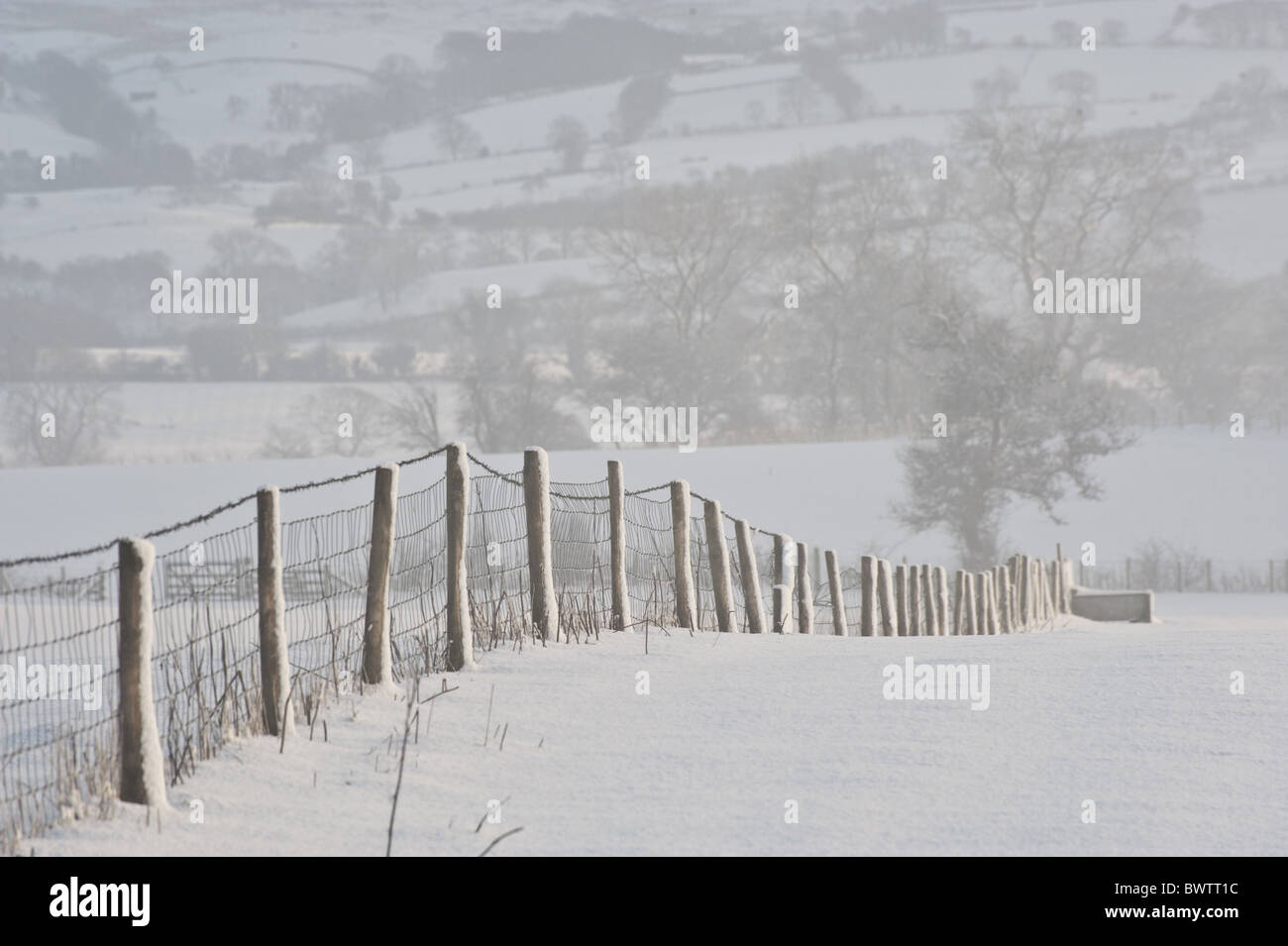 Wire fence with stile snow mist Clitheroe Stock Photo - Alamy