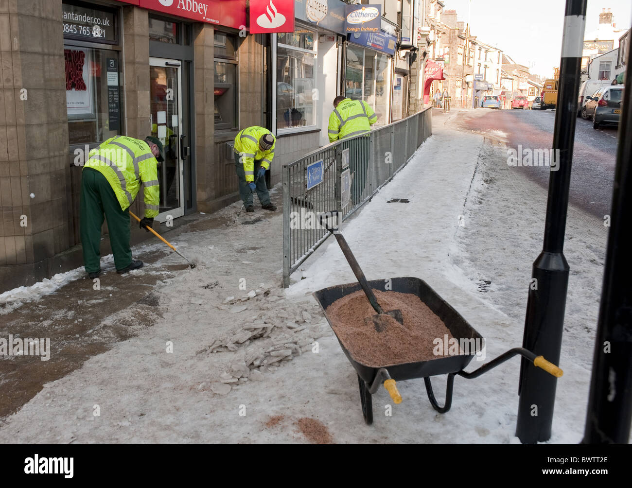 Council workers clearing ice gritting pavement Stock Photo - Alamy
