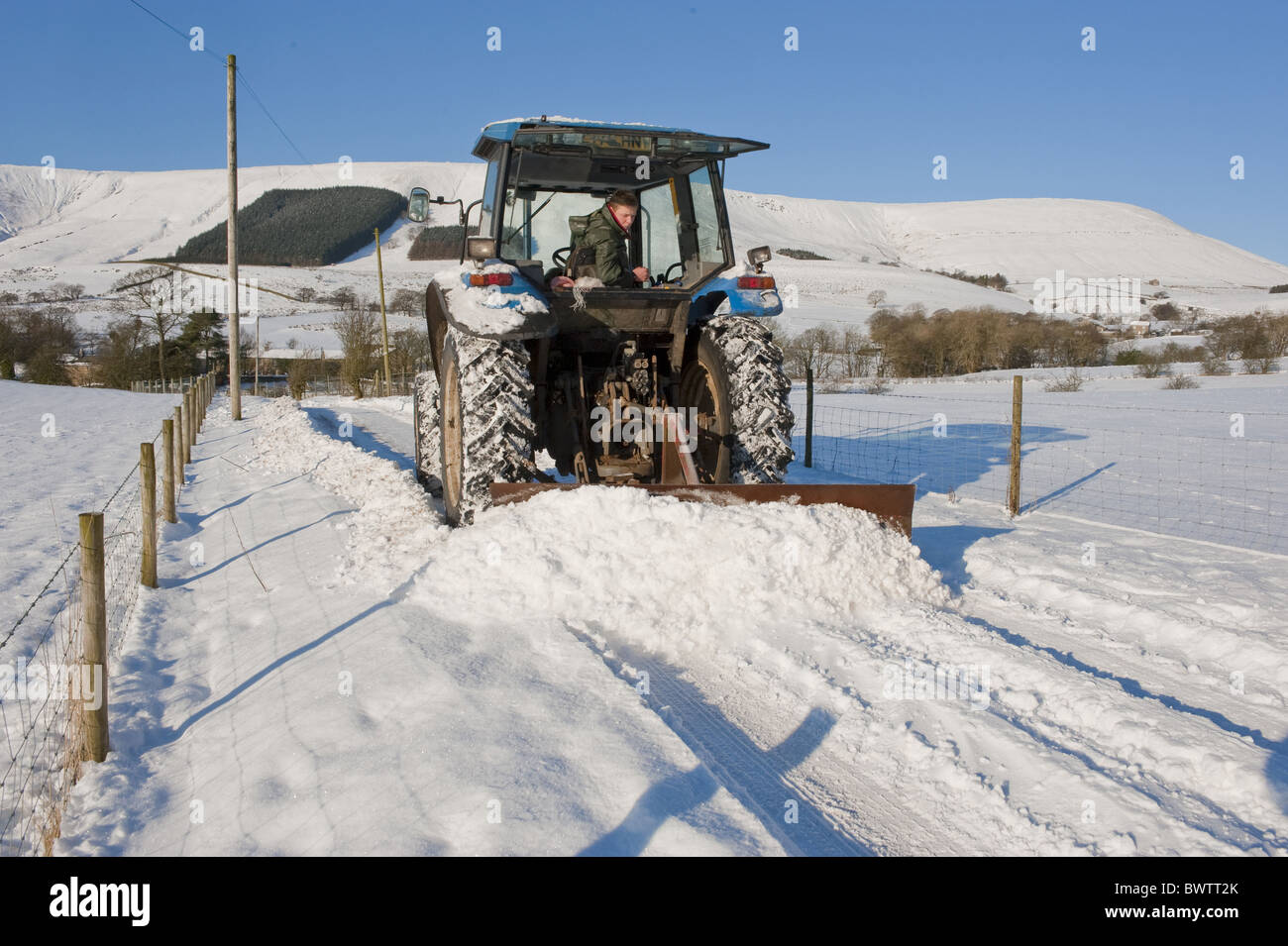 New Holland tractor clearing snow from farm track Stock Photo - Alamy