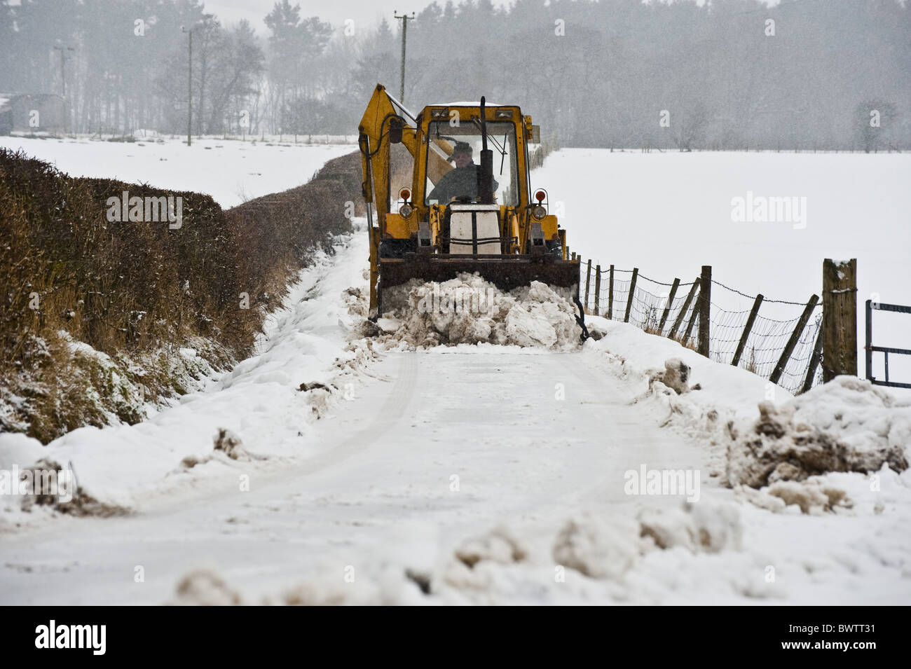 JCB clearing snow from farm track Whitewell Stock Photo - Alamy