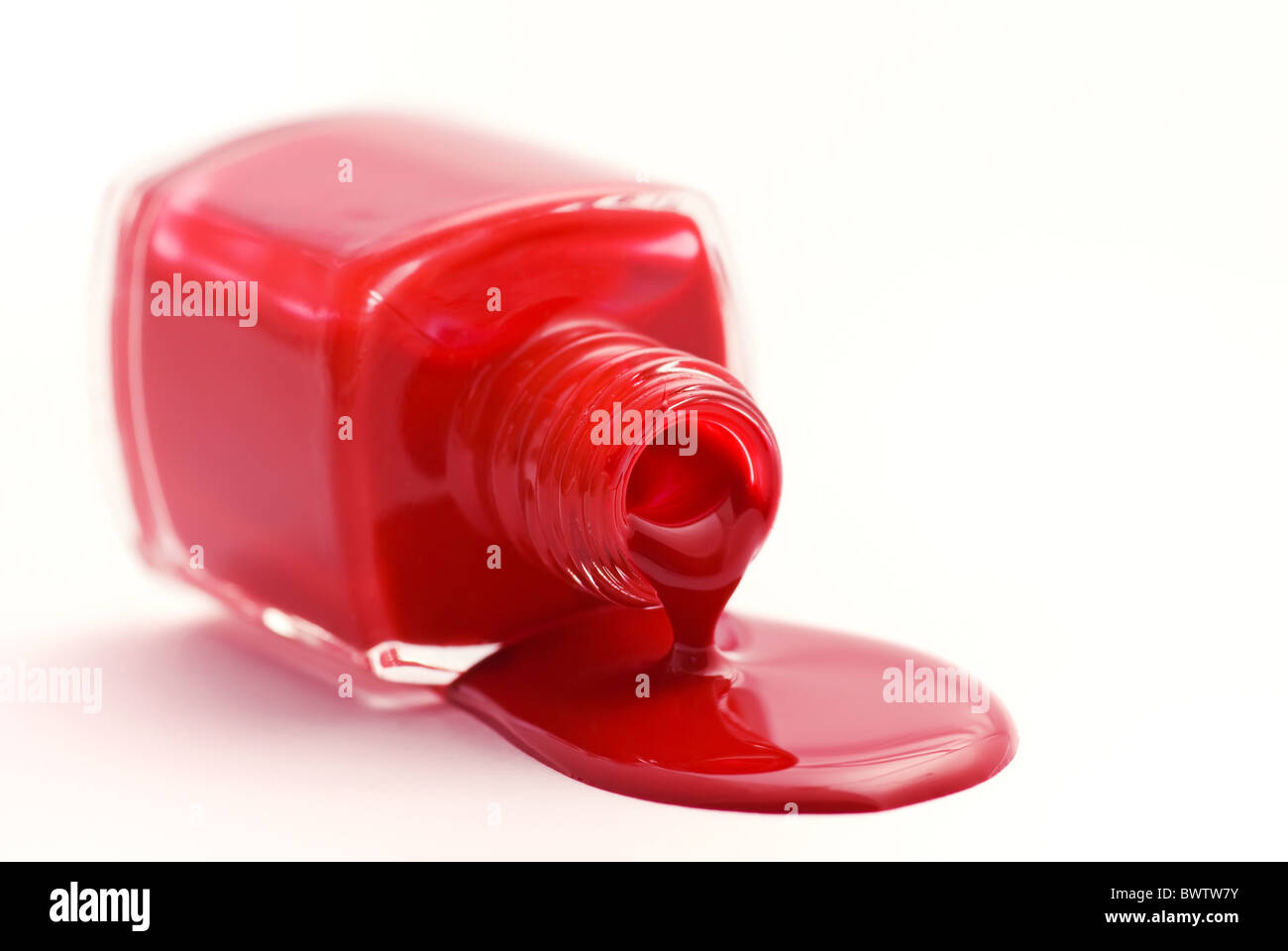 Open Flask with dropping nail polish as closeup on white background ...