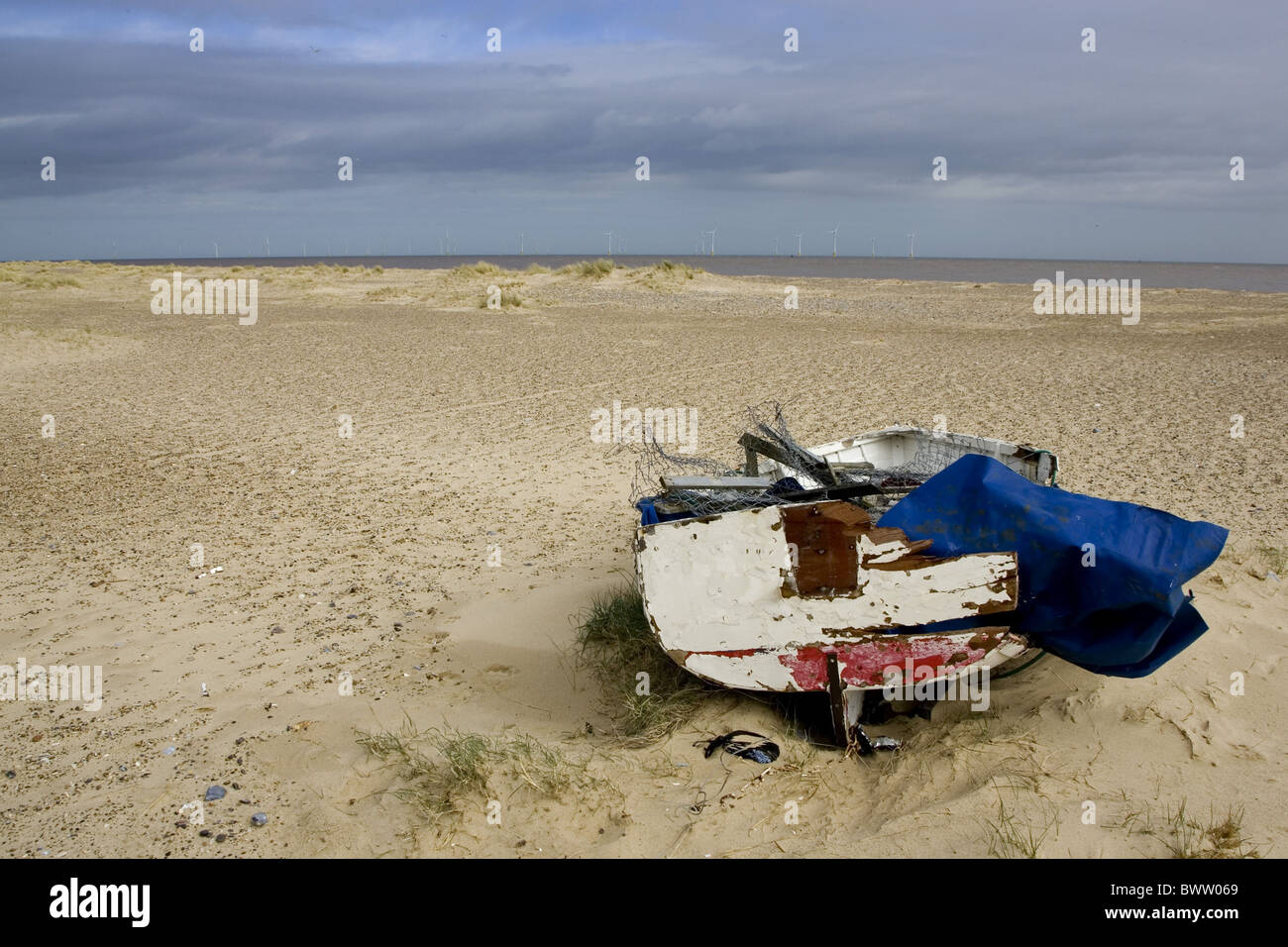 Boat wreck sandy beach wind turbines off-shore Stock Photo - Alamy