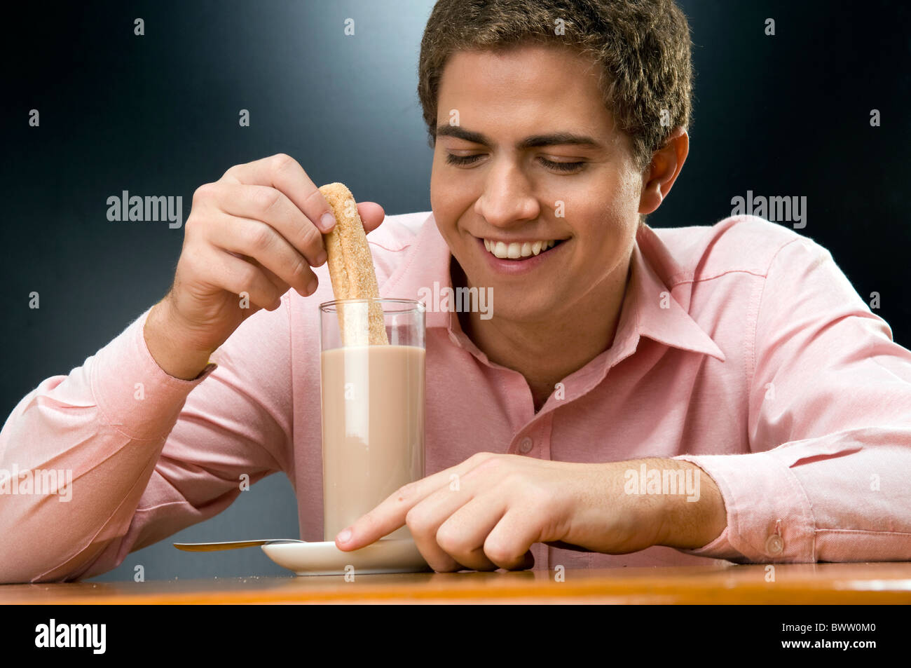 Man dipping cookie in chocolate milk Stock Photo - Alamy