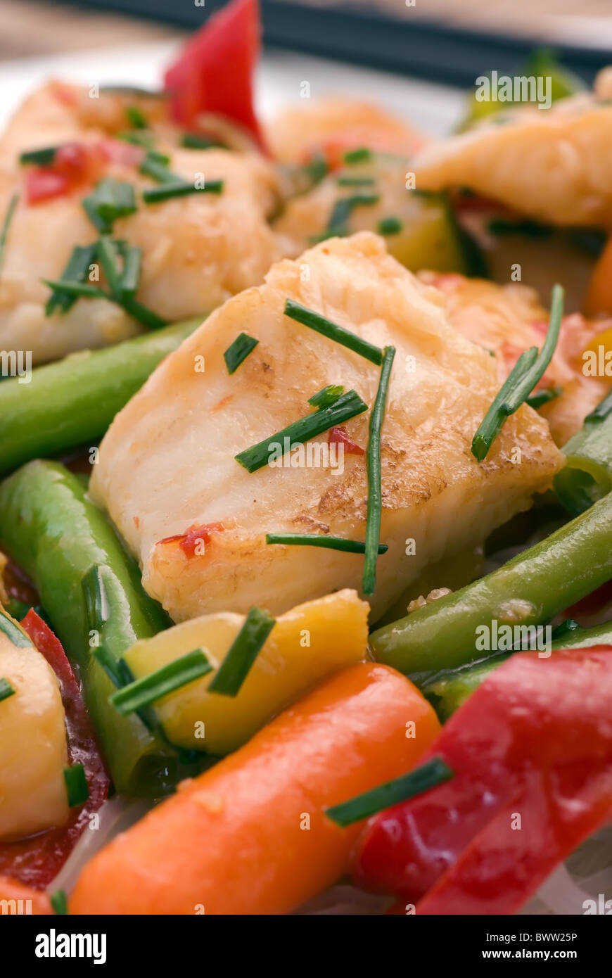 Thai Fish with Vegetable and rice noodles as closeup in a white plate ...