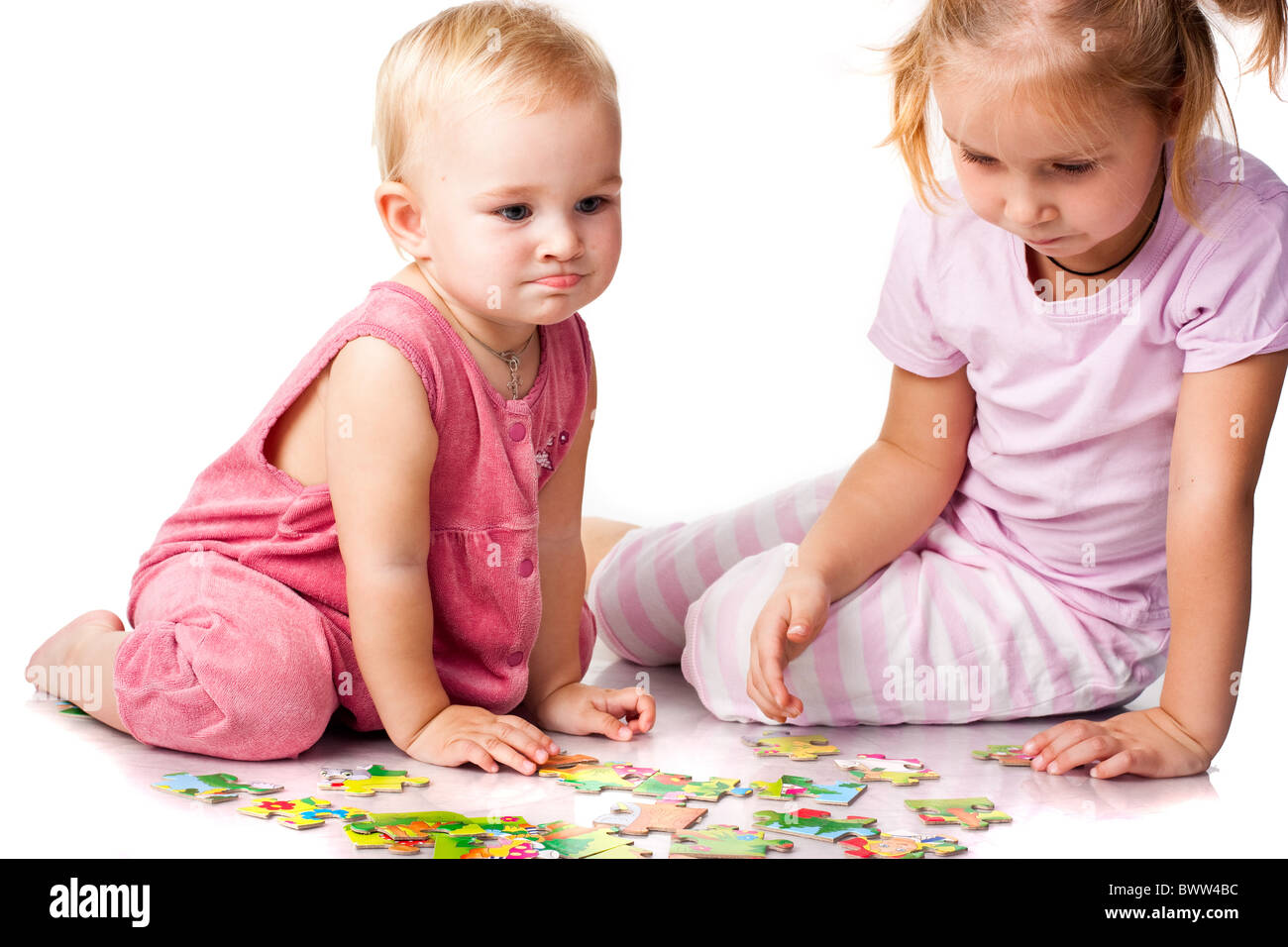 Children solving jigsaw puzzle isolated on white Stock Photo - Alamy