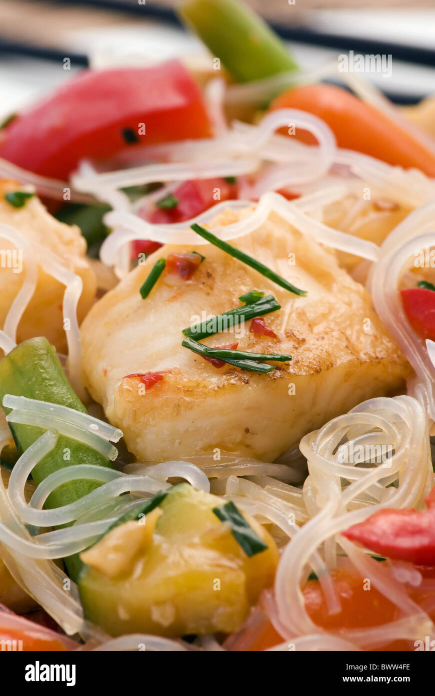 Thai Fish with Vegetable and rice noodles as closeup in a white plate ...