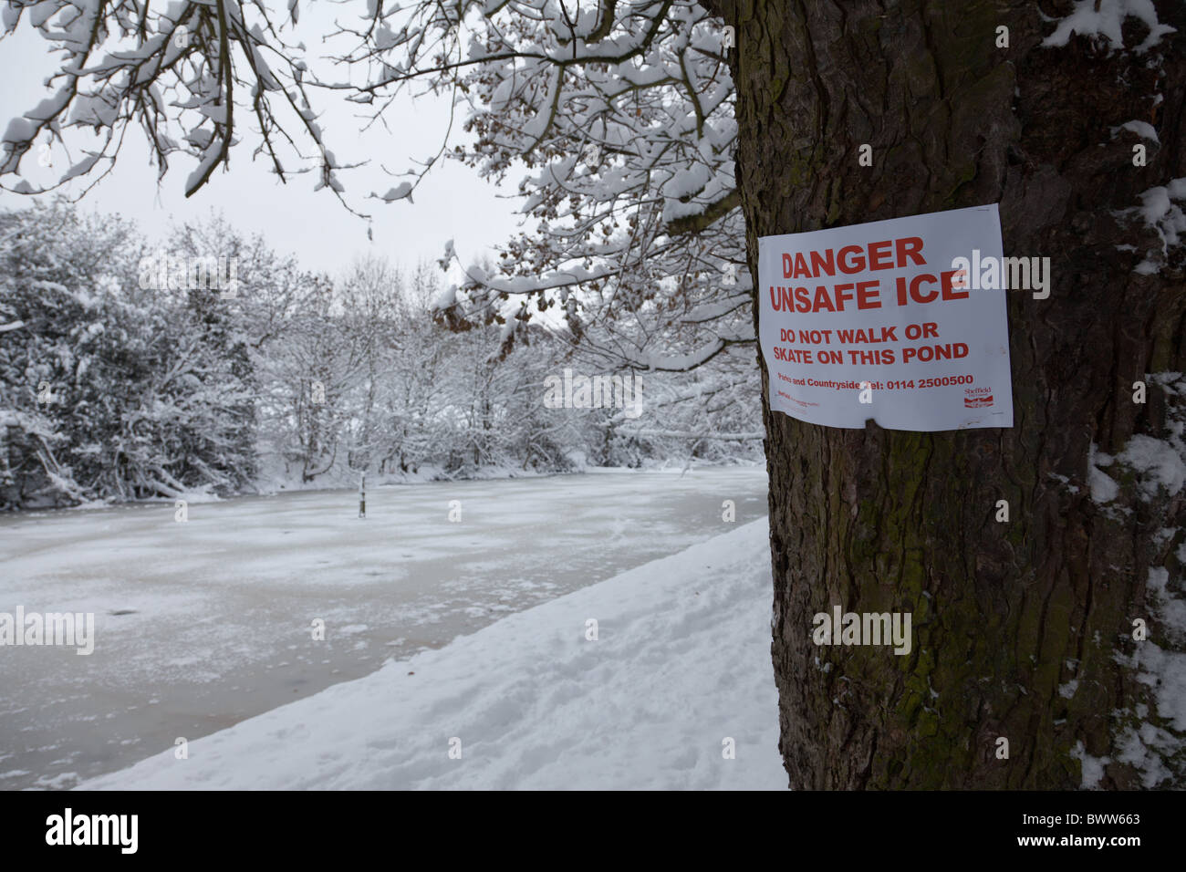 Danger unsafe ice sign by wire mill dam in Sheffield in winter Stock ...