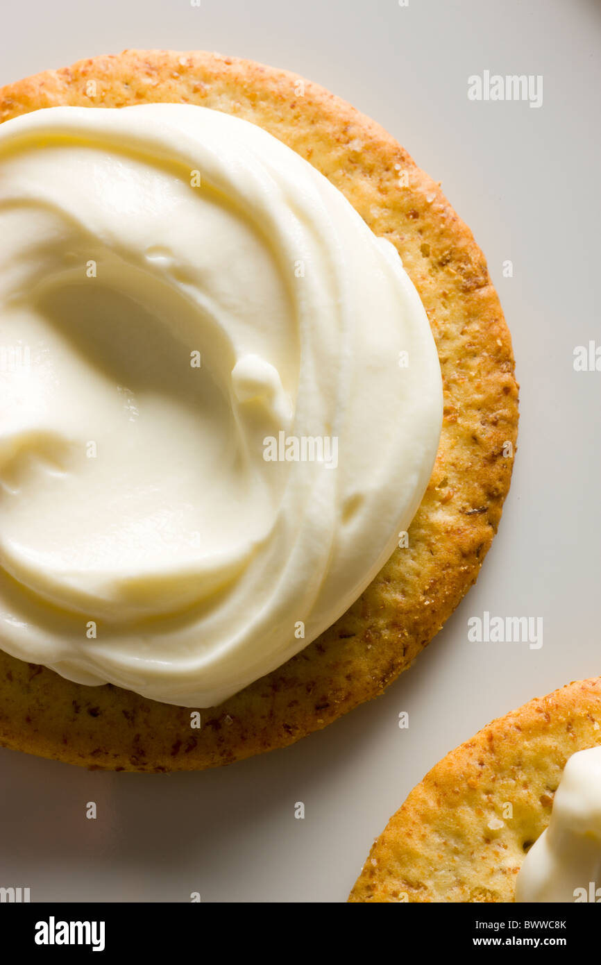 Crackers with Creamy Cheese spread on top on a white rectangular ...